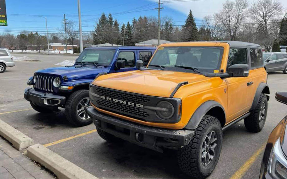Spotted: Bronco Badlands Cyber Orange vs Jeep Wrangler Sahara -- side ...